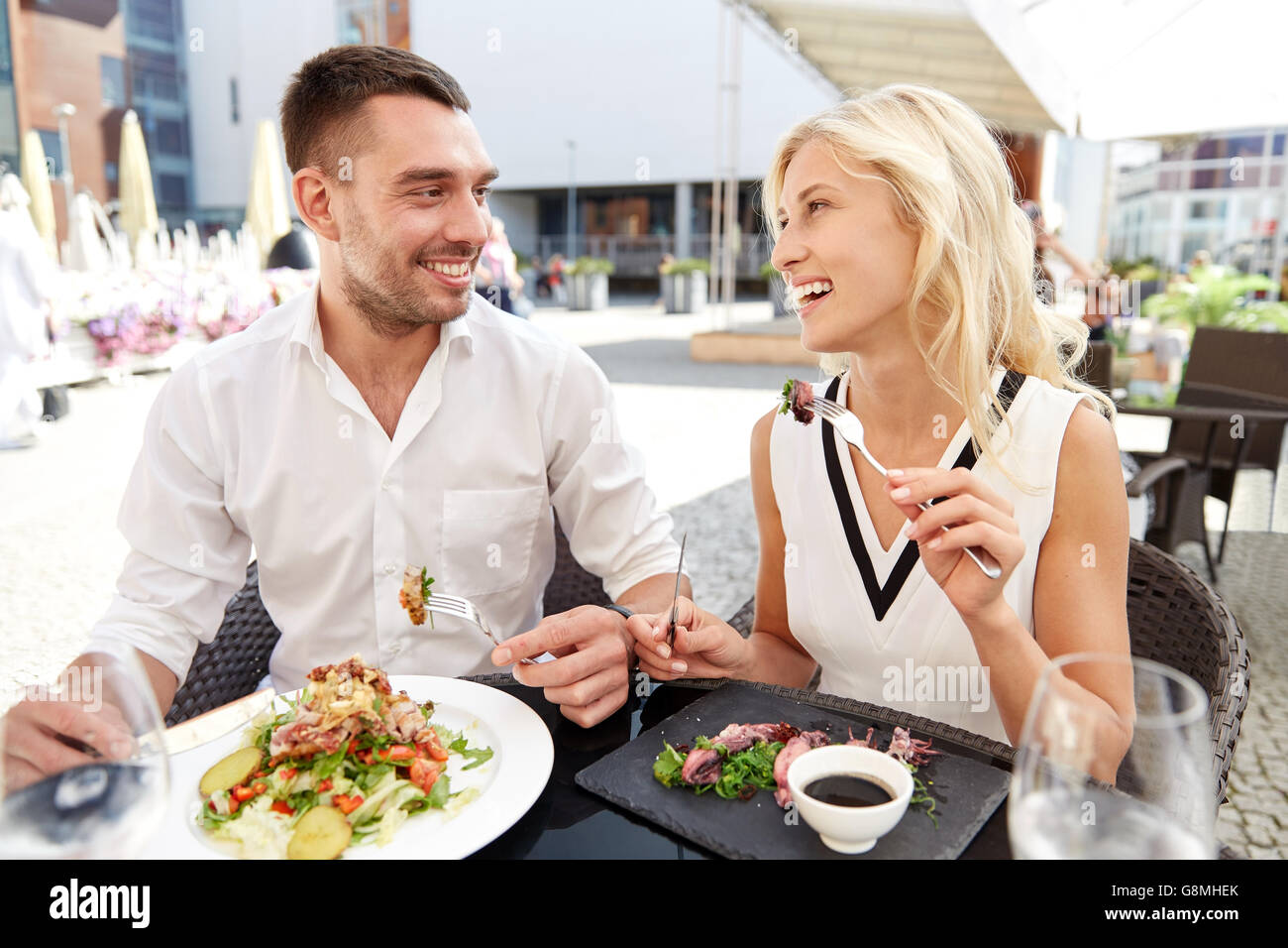 happy couple eating dinner at restaurant terrace Stock Photo - Alamy