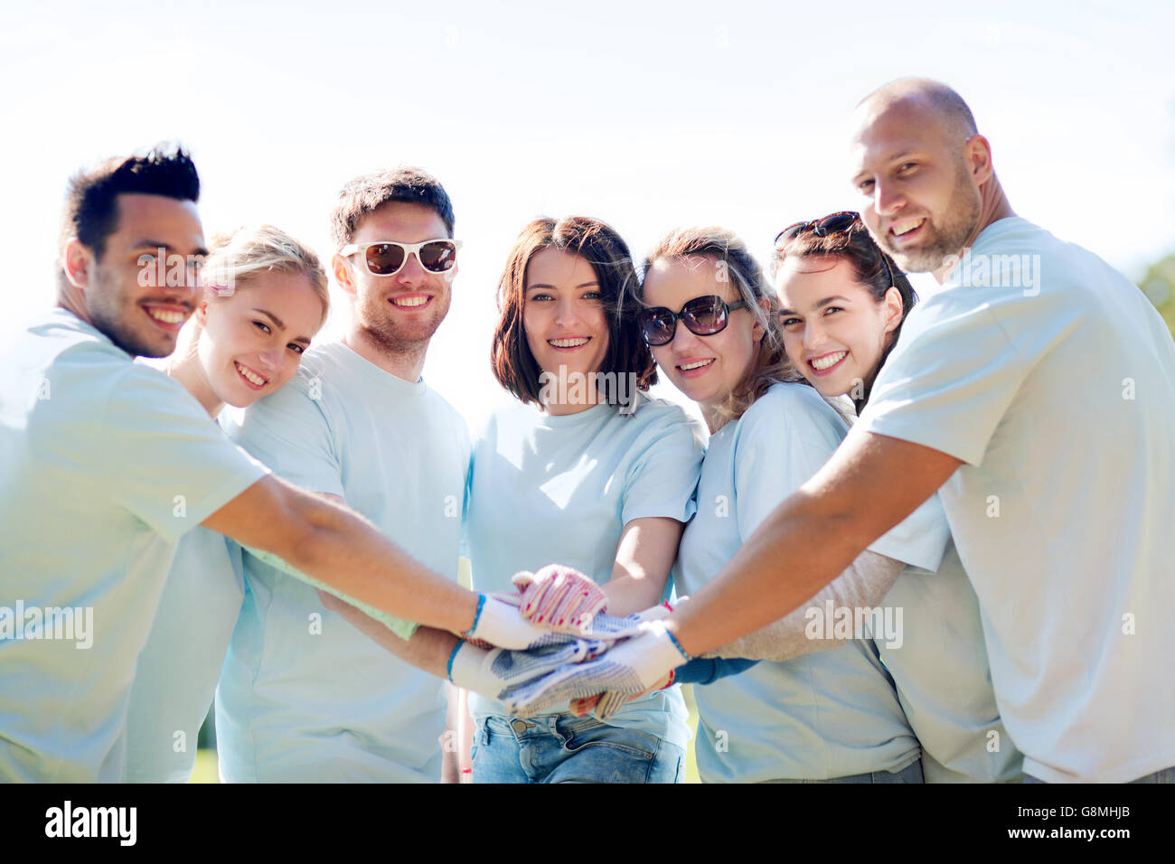 Group volunteers putting hands hi-res stock photography and images - Alamy
