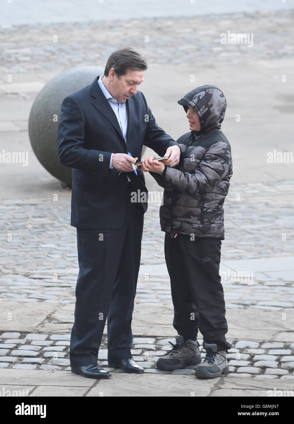 Former Coventry City chairman Ray Ranson signs an autograph for a young ...