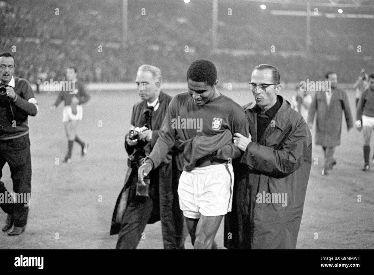 Portugal's Eusebio is consoled by a compatriot as he trudges dejectedly ...