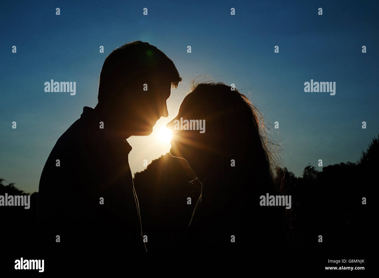 Silhouette of man and woman on the background of the setting sun Stock ...