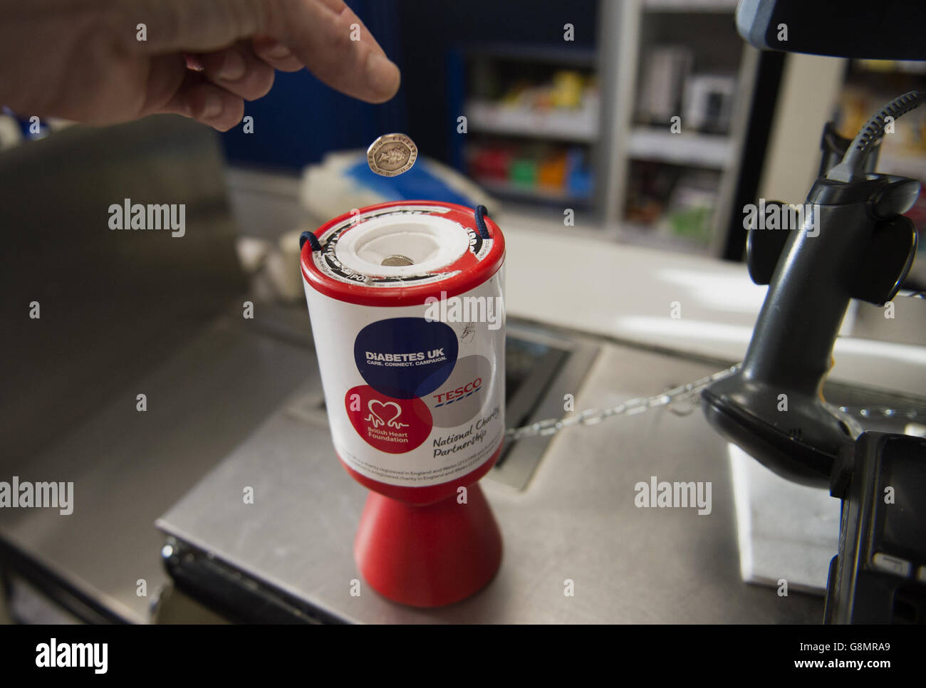 PICTURE POSED BY PHOTOGRAPHER A coin is dropped into a charity ...