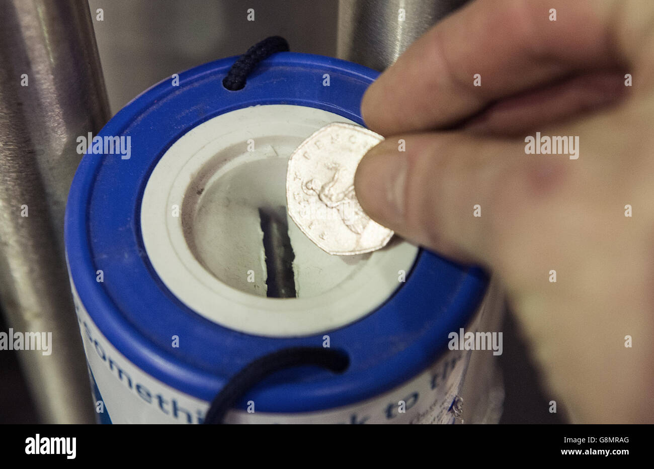 PICTURE POSED BY PHOTOGRAPHER A coin is dropped into a charity ...