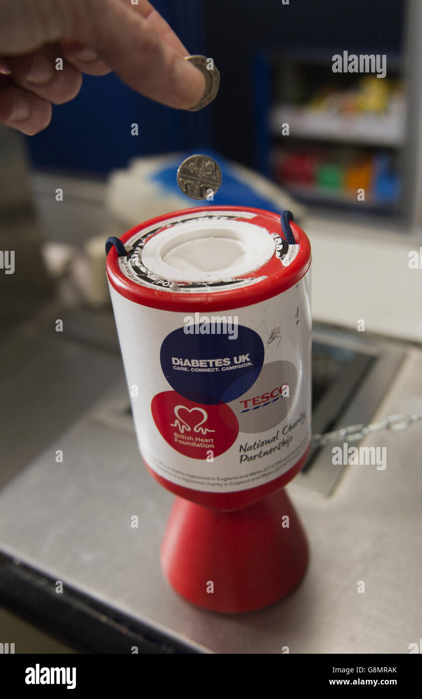 PICTURE POSED BY PHOTOGRAPHER A coin is dropped into a charity ...