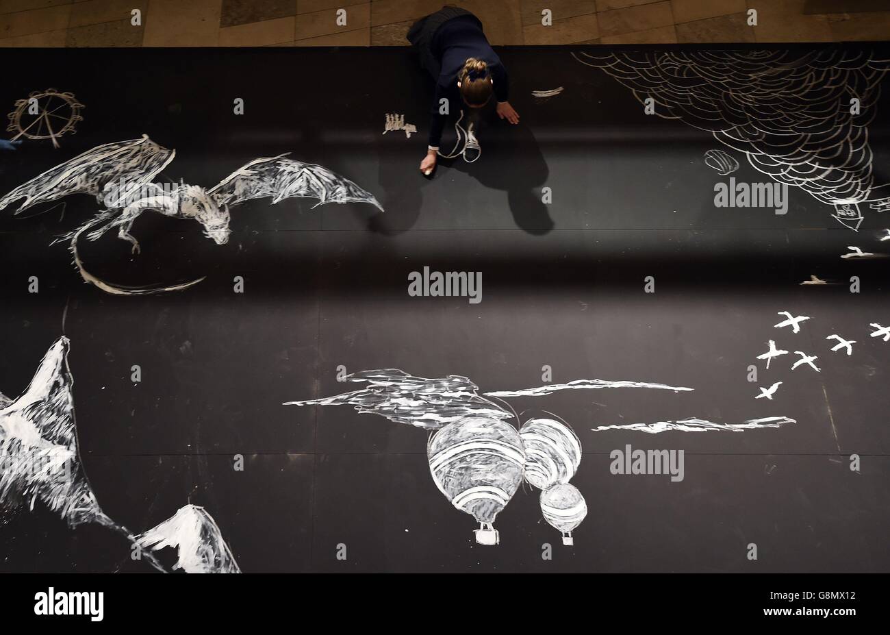 A schoolgirl draws on part of the 'Giant Chalkboard Floor', a 21x9 ...