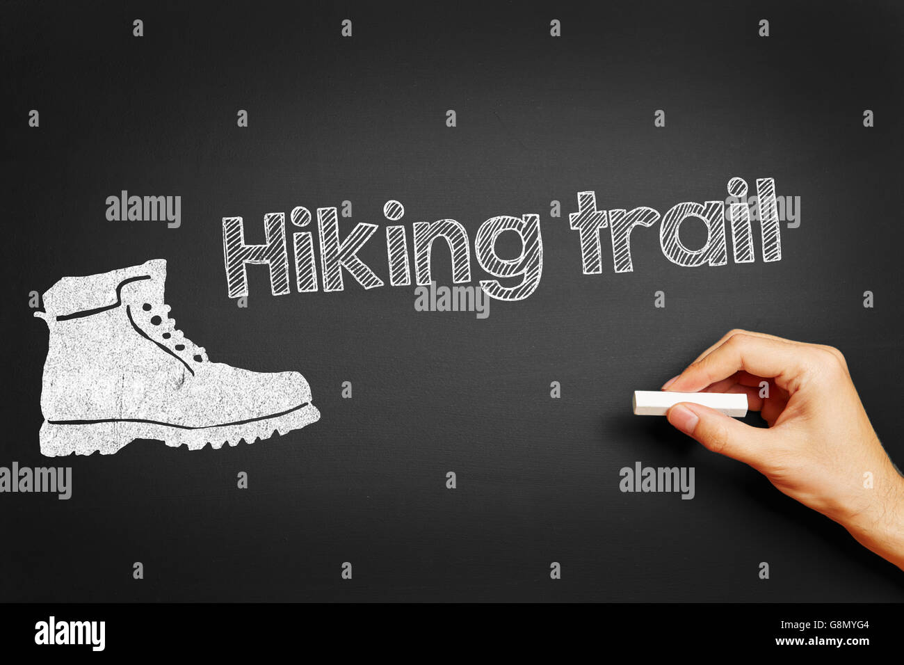 Hand with chalk writing "Hiking trail" on a blackboard Stock Photo - Alamy