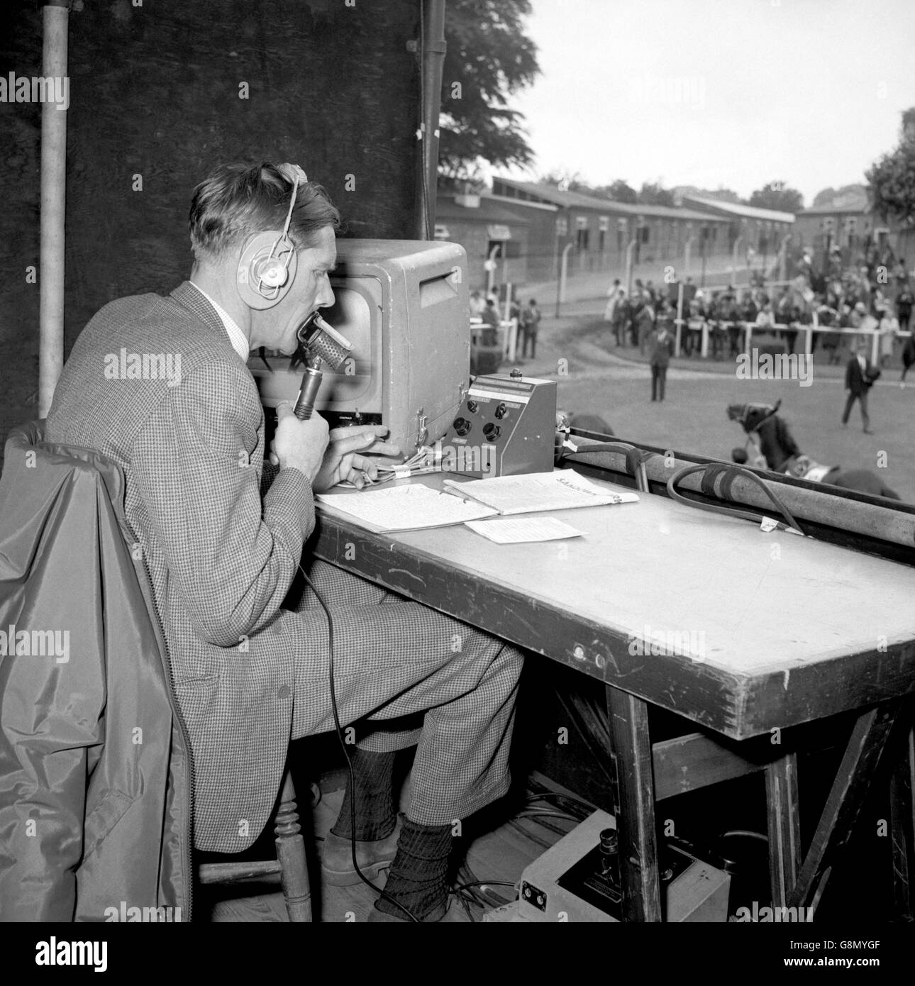 Race announcer and commentator at his desk at Sandown Park racecourse ...
