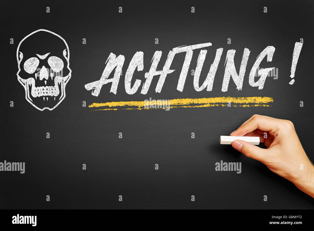 Hand with chalk writing in German "Achtung!" (Attention) on a ...