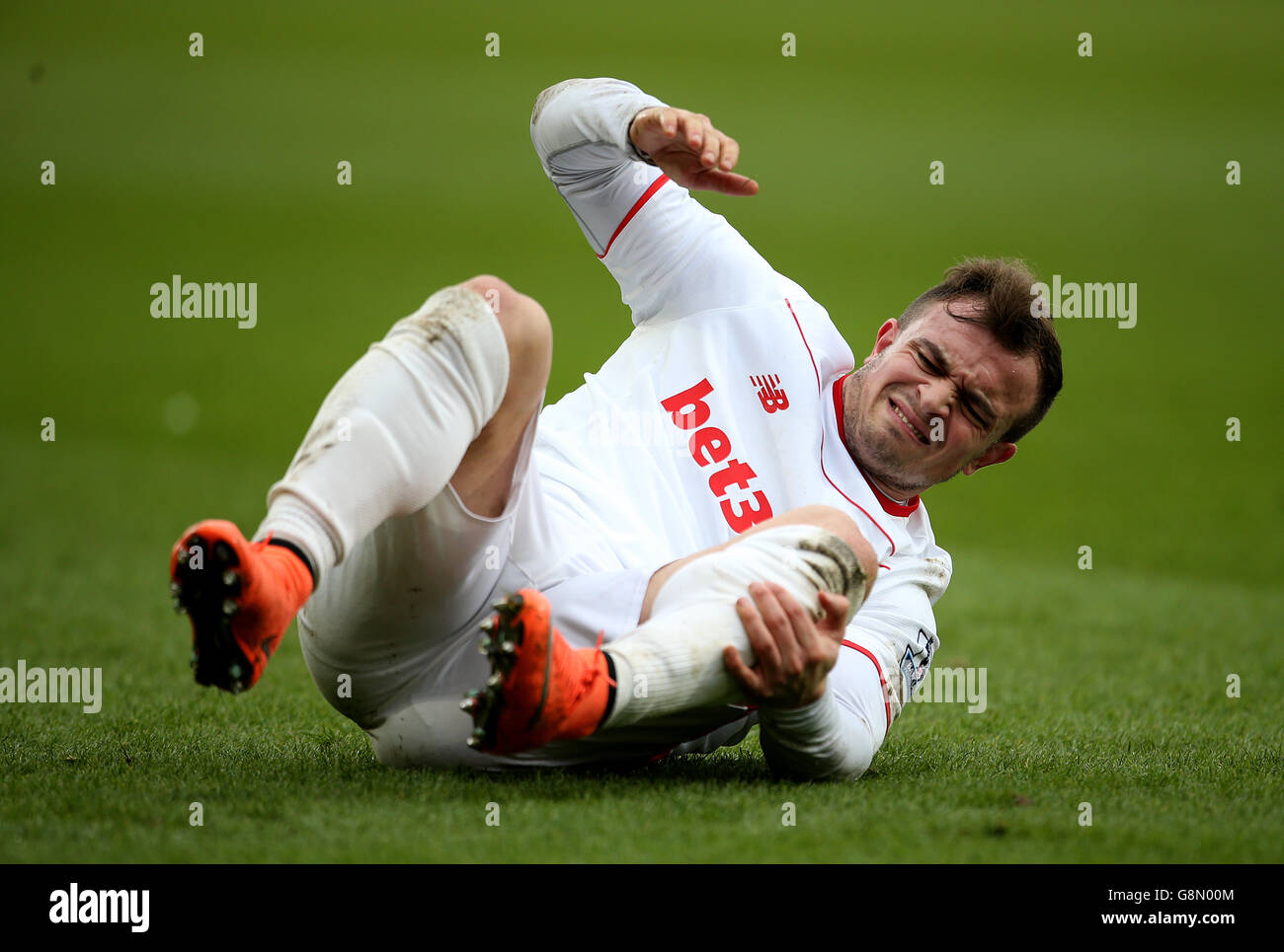 Stoke City's Xherdan Shaqiri holds his leg after going down for a ...