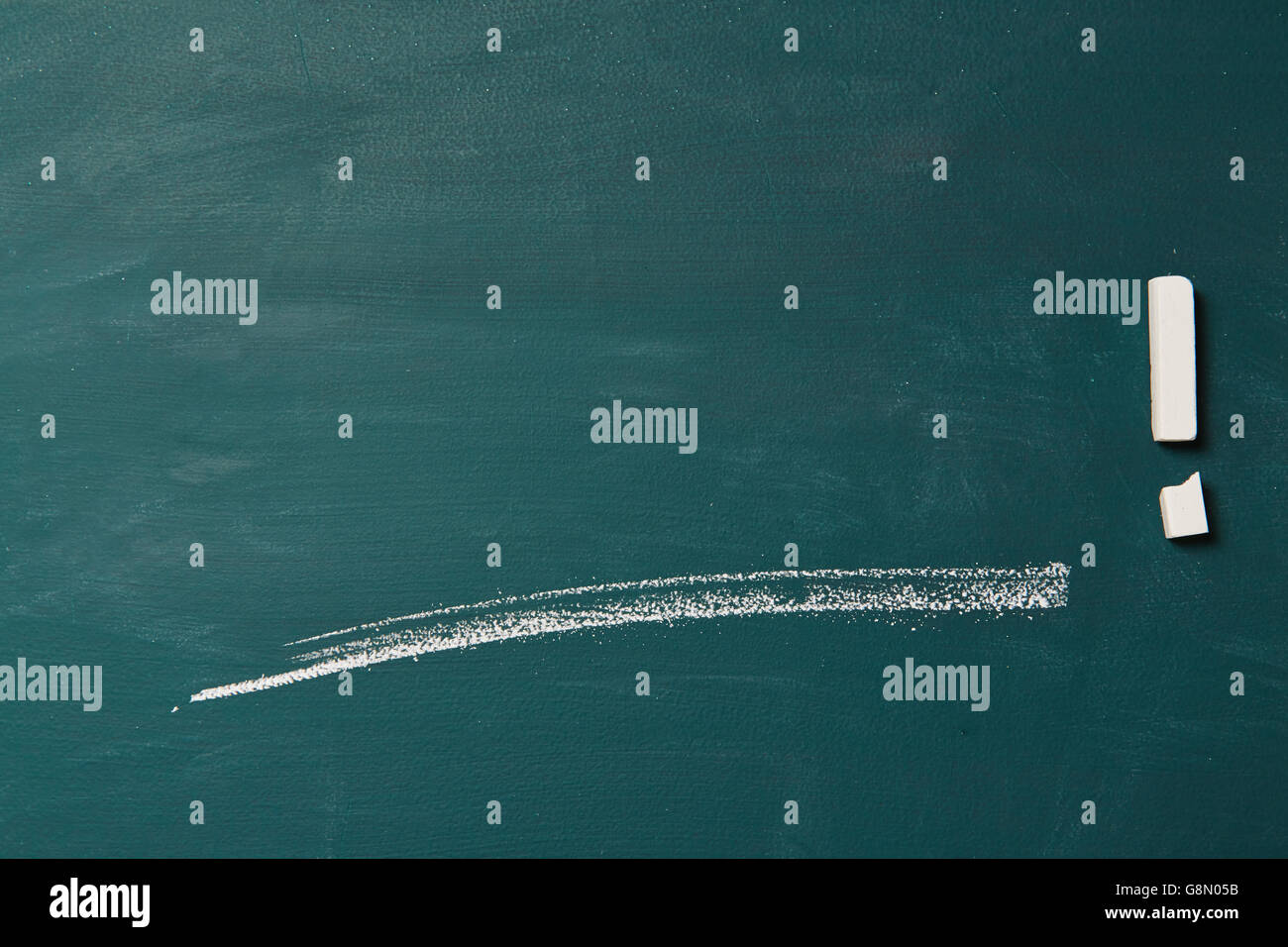 Empty green chalkboard with line and broken chalk as exclamation point ...