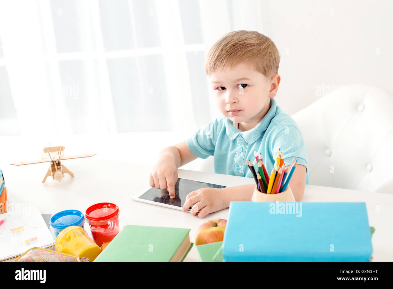 Modern problem: kids and computers. Little boy using tablet computer ...