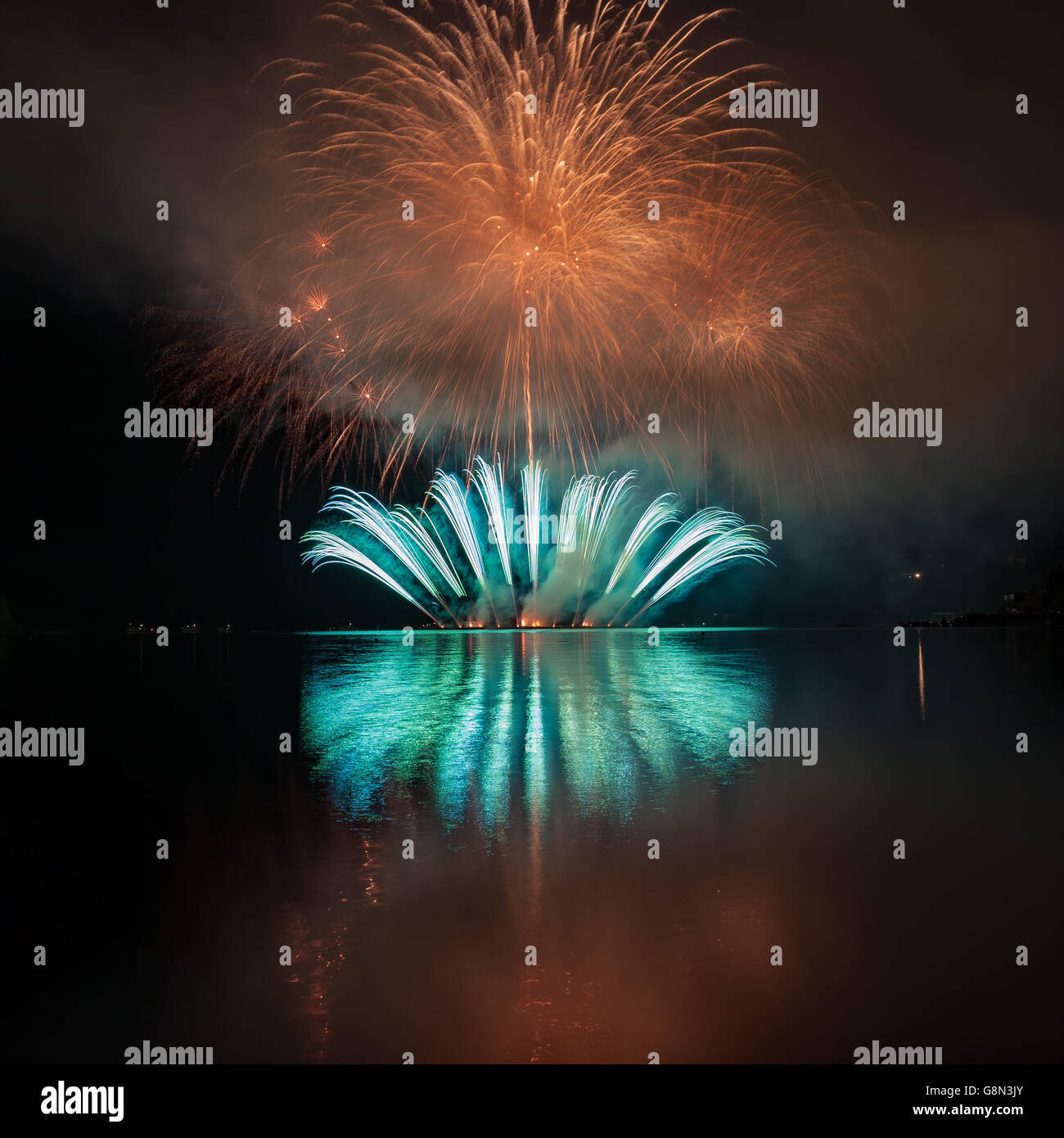 Colorful fireworks with reflection on lake and night sky in background ...