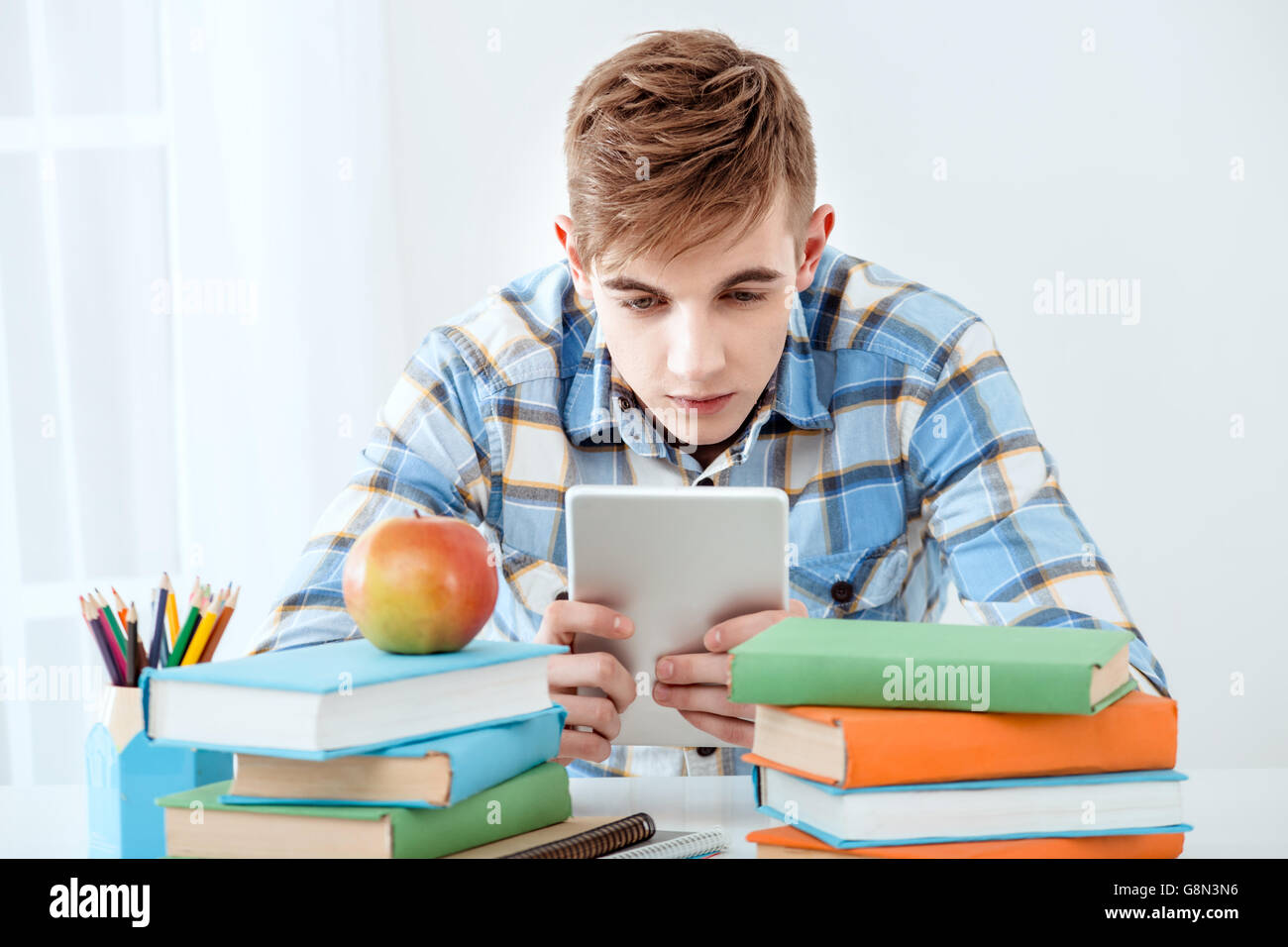 Modern problem: youth and computers. Young student using tablet ...