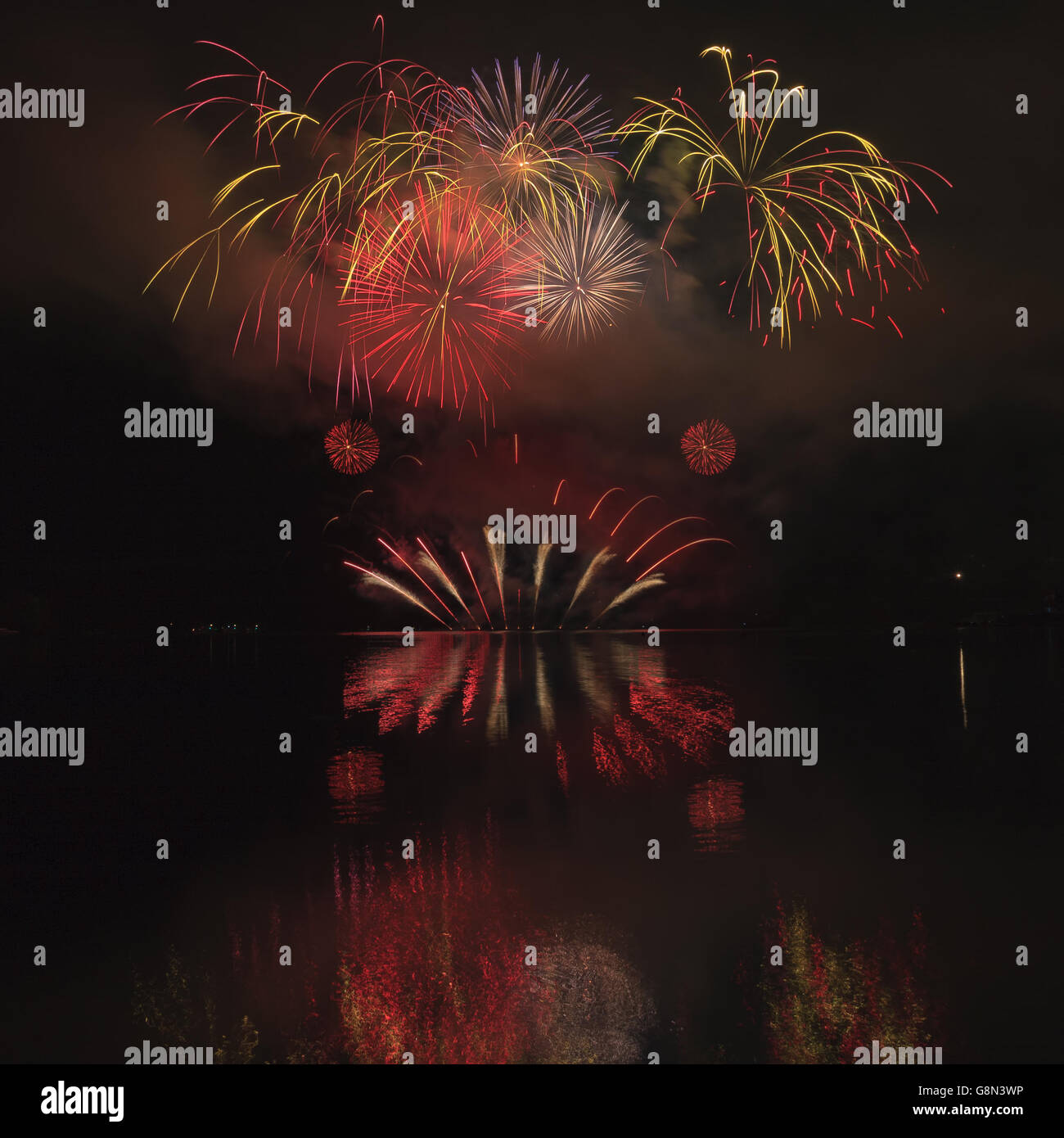 Colorful fireworks with reflection on lake and night sky in background ...