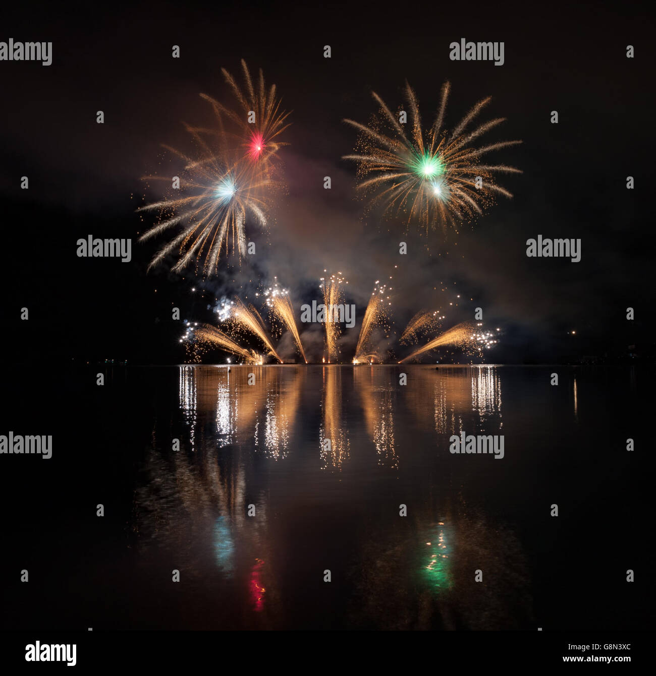 Colorful fireworks with reflection on lake and night sky in background ...