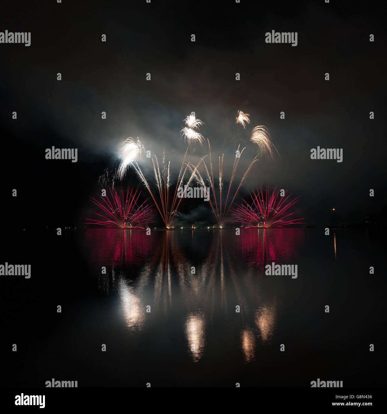 Colorful fireworks with reflection on lake and night sky in background ...