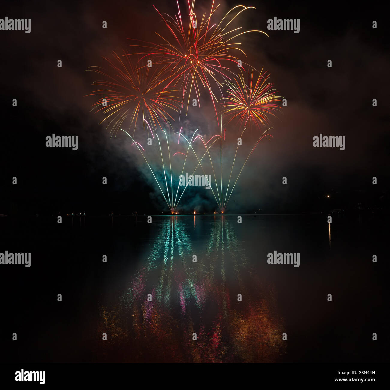 Colorful fireworks with reflection on lake and night sky in background ...