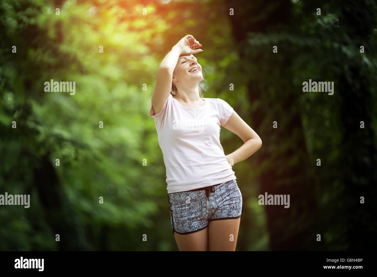 Tired female jogger resting after jogging Stock Photo - Alamy