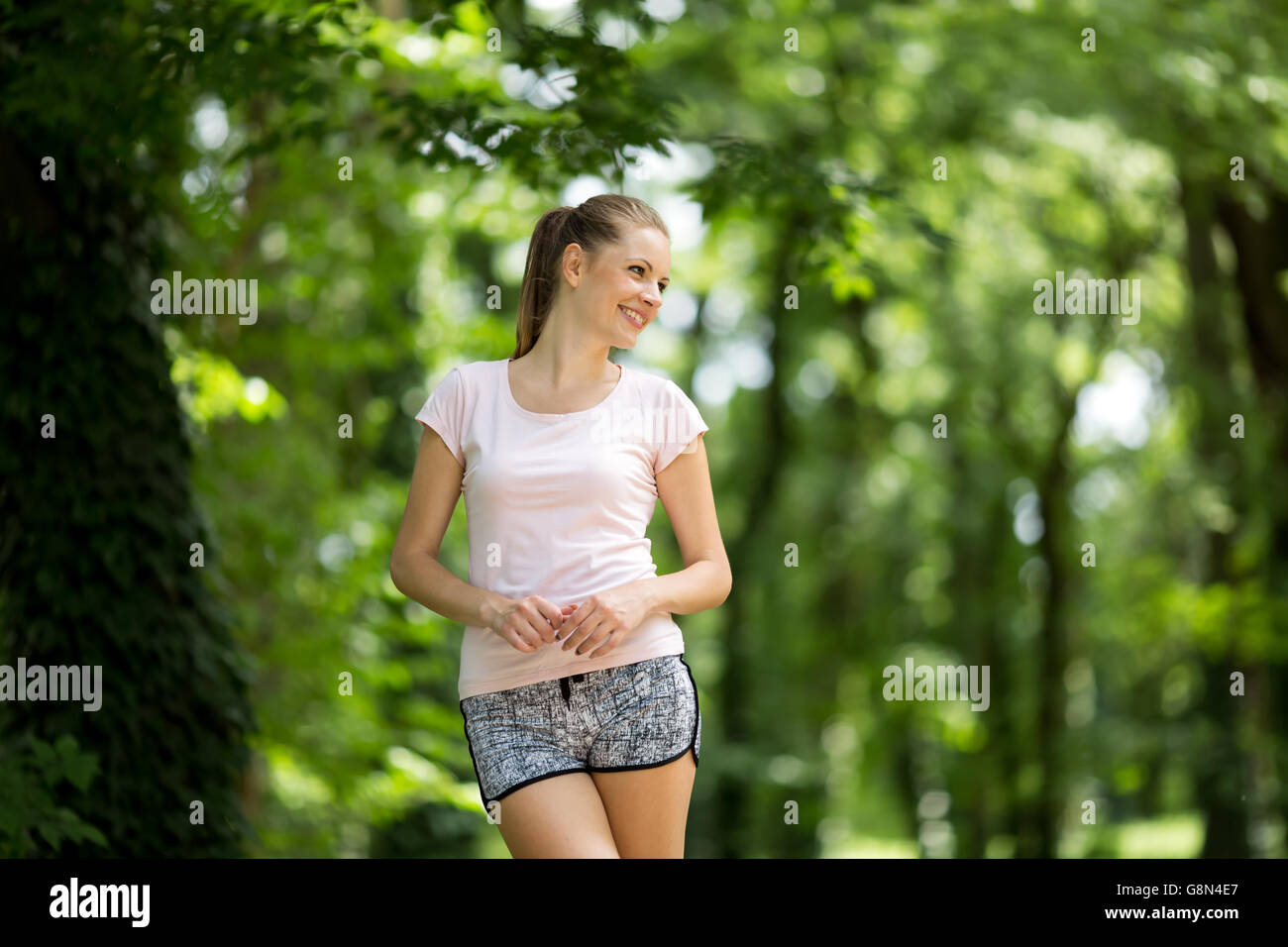 Beautiful athletic female jogger in nature Stock Photo - Alamy