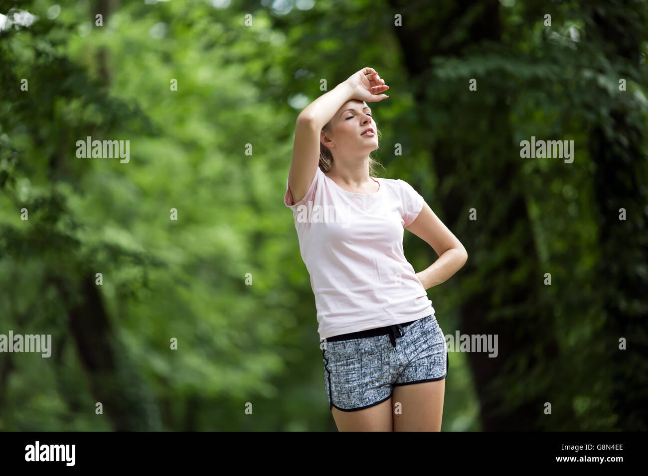 Tired female jogger resting after jogging Stock Photo - Alamy