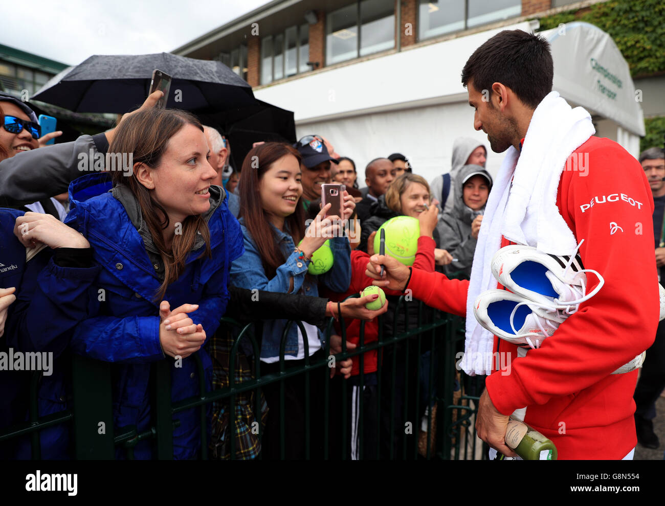 Novak Djokovic signs autographs for fans on day Three of the Wimbledon ...