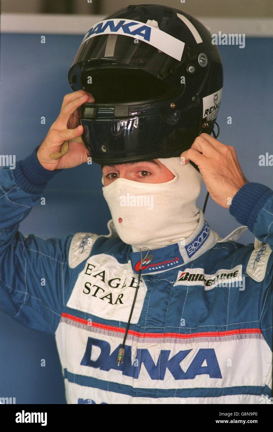 Damon Hill pulls on his helmet as he prepares to practise Stock Photo ...