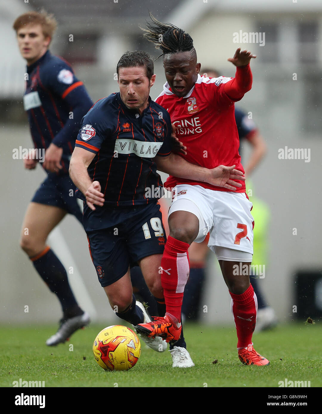 Swindon Town's Drissa Traore and Blackpool's David Norris (centre ...