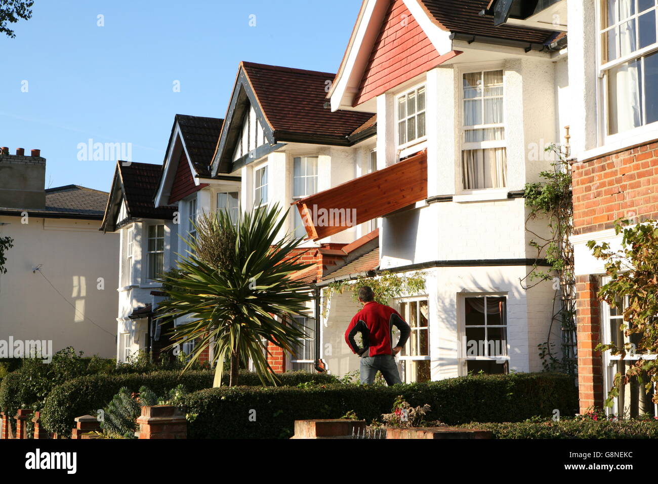 Removal men get a cupboard stuck in the upstairs window of a house in ...