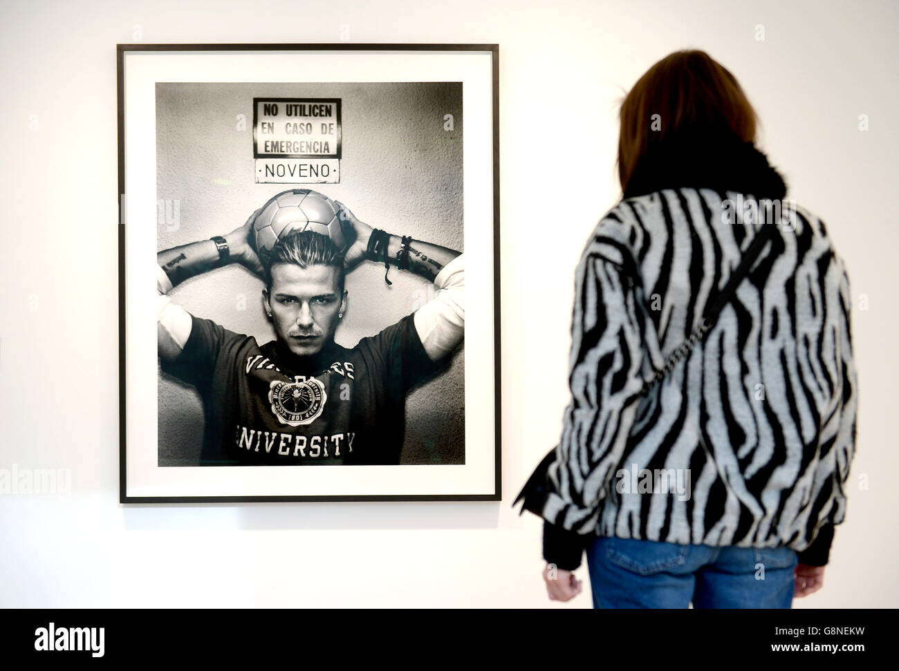 A woman views a photograph of David Beckham by Marc Hom at Phillips ...