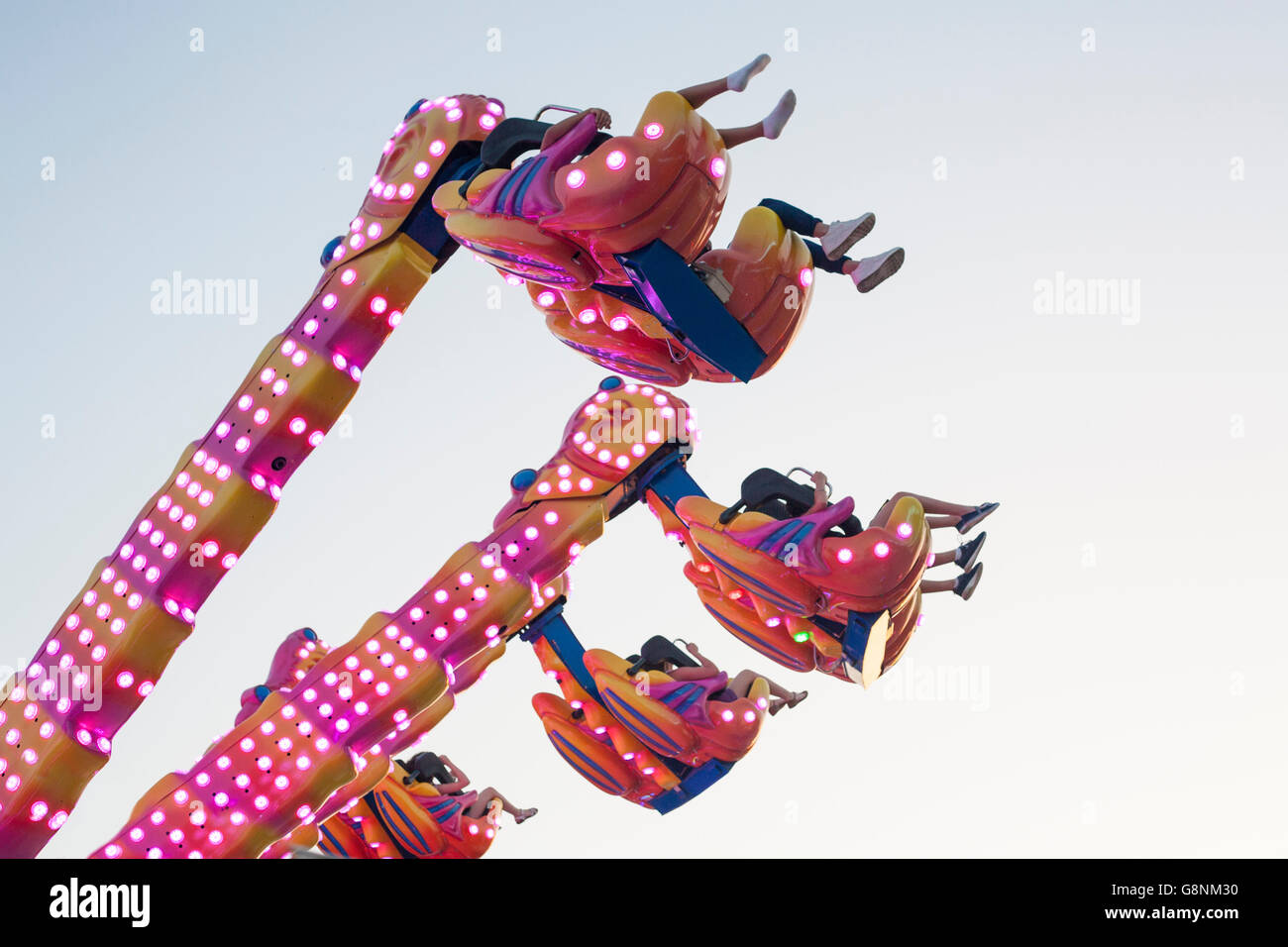 Hanging funfair attraction with people having fun low angle view hi-res ...