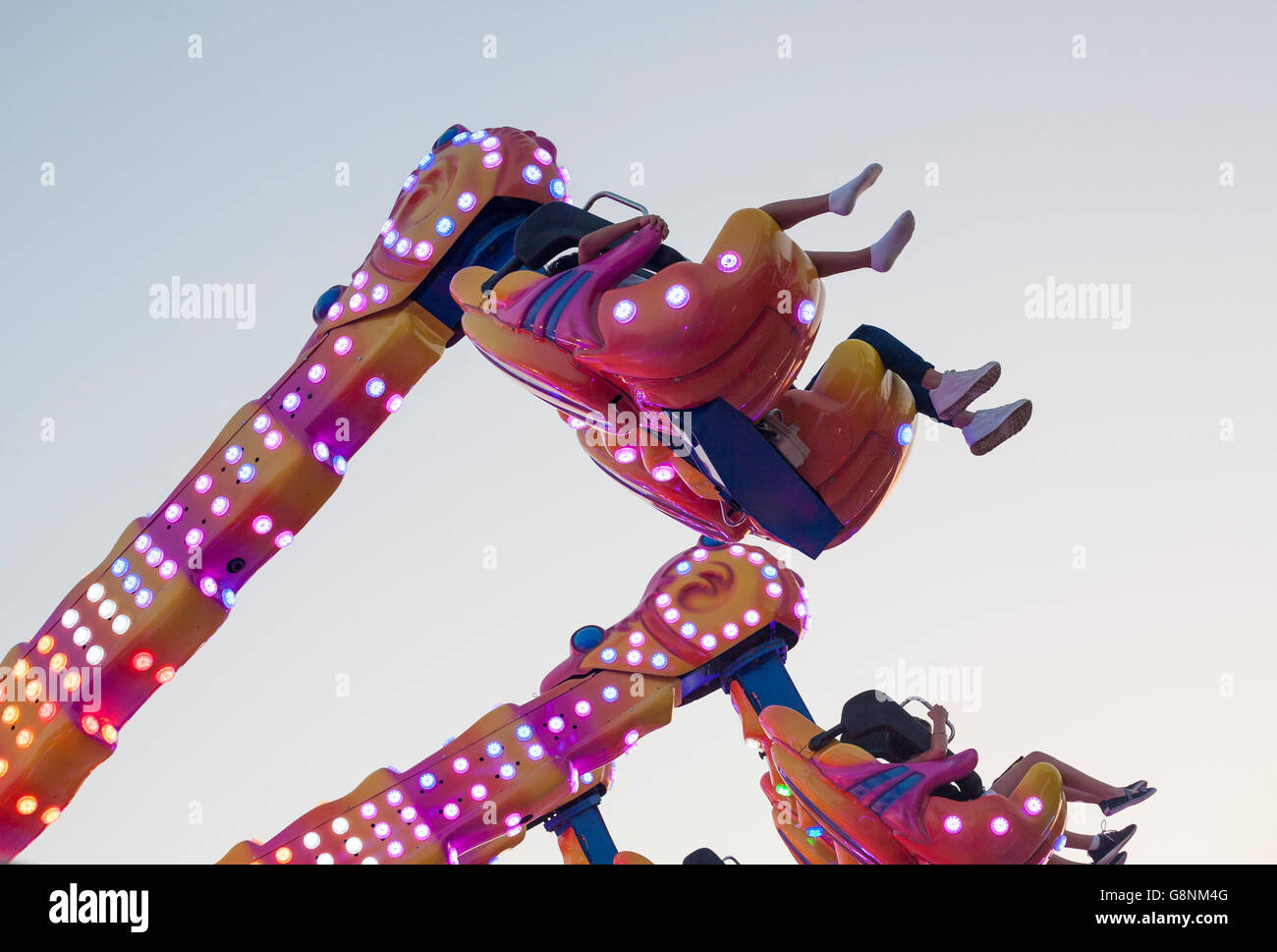 Hanging funfair attraction with people having fun. low angle view Stock ...