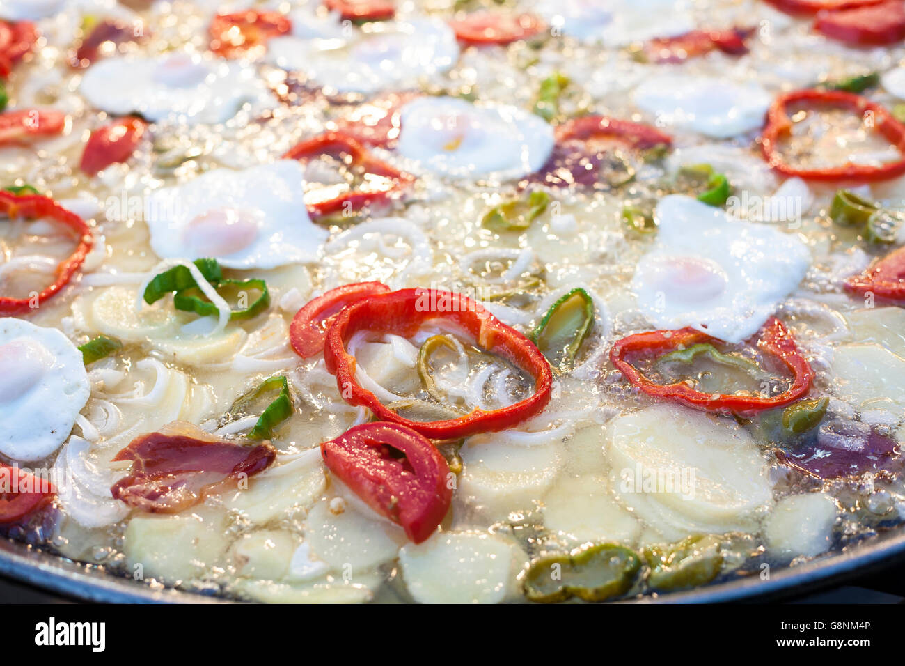 Boiling huge pan with eggs, pepper slices, potatoes and onions Stock ...
