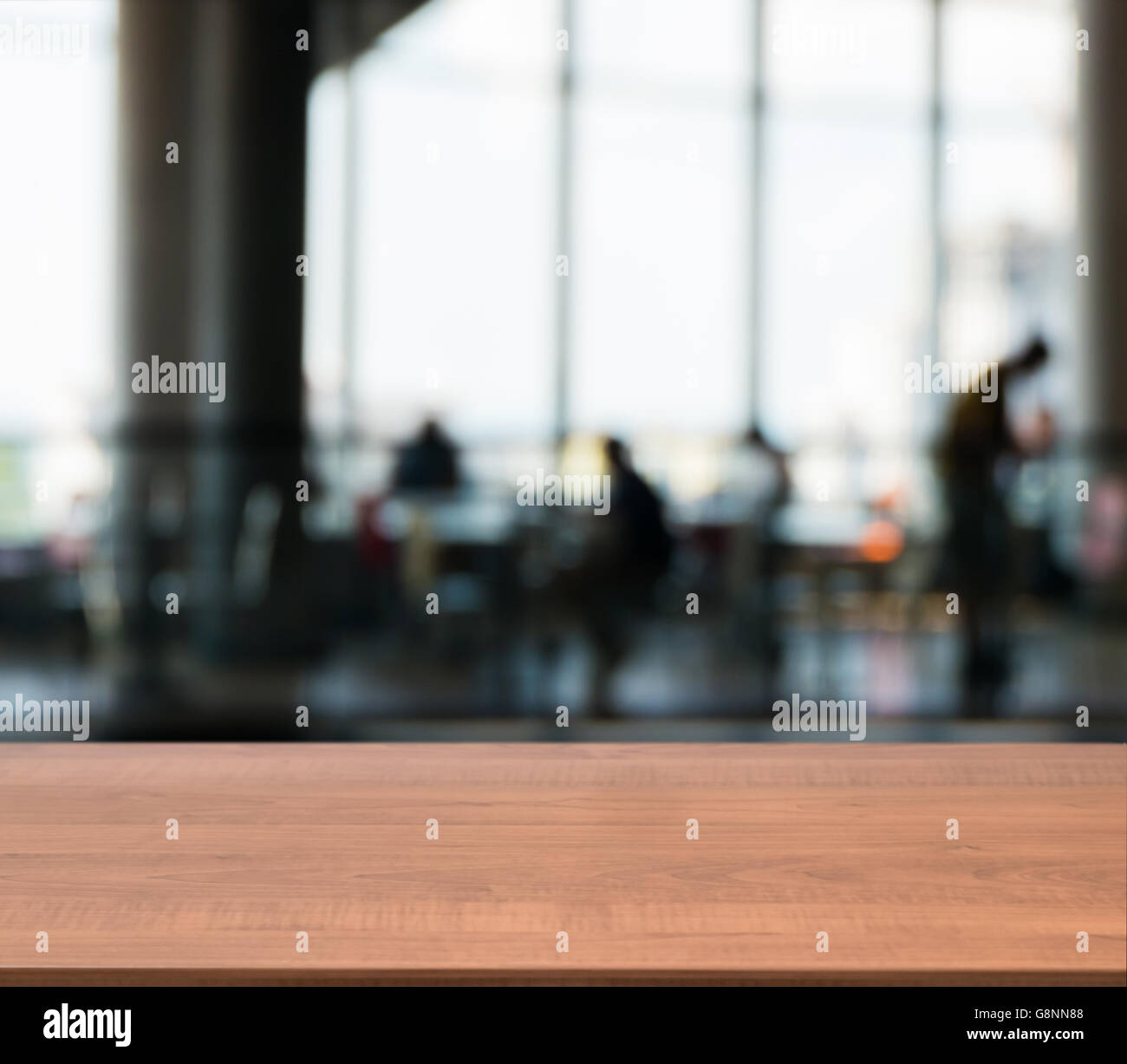 Wooden empty table in front of blurred people Stock Photo - Alamy
