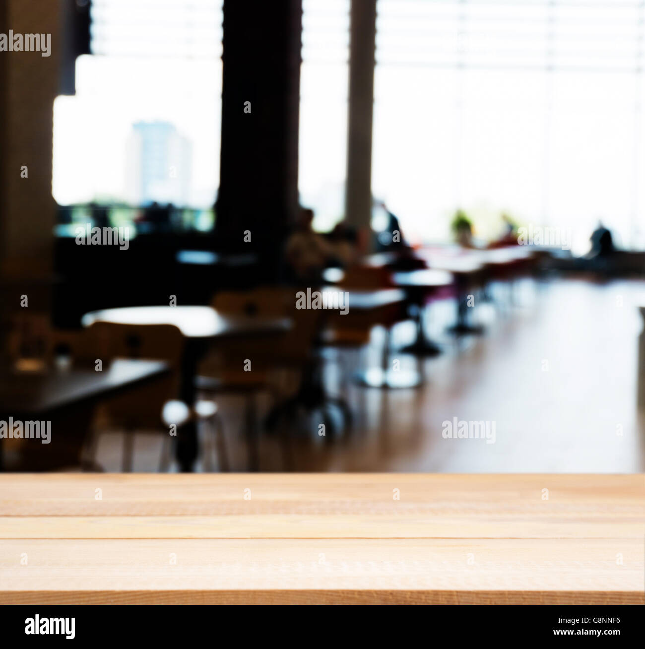 Wooden empty table in front of blurred people Stock Photo - Alamy