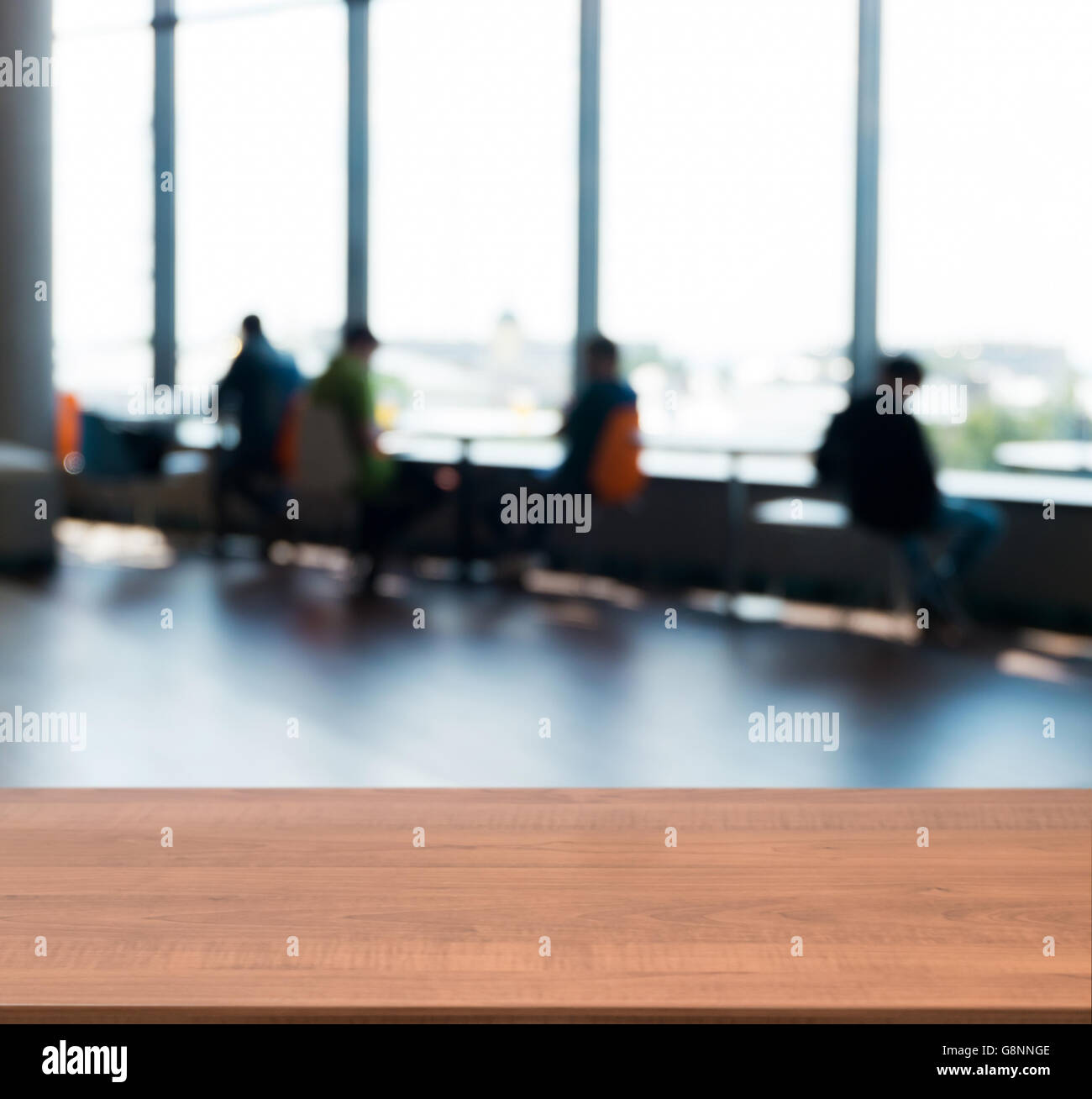 Wooden empty table in front of blurred people Stock Photo - Alamy