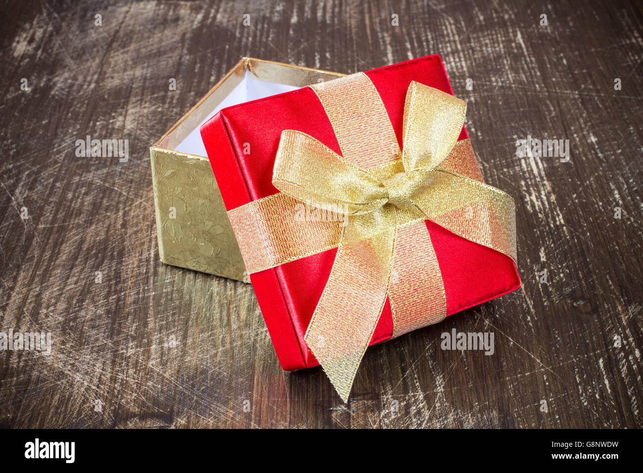 Open gift box with golden ribbon on the old wooden floor Stock Photo ...