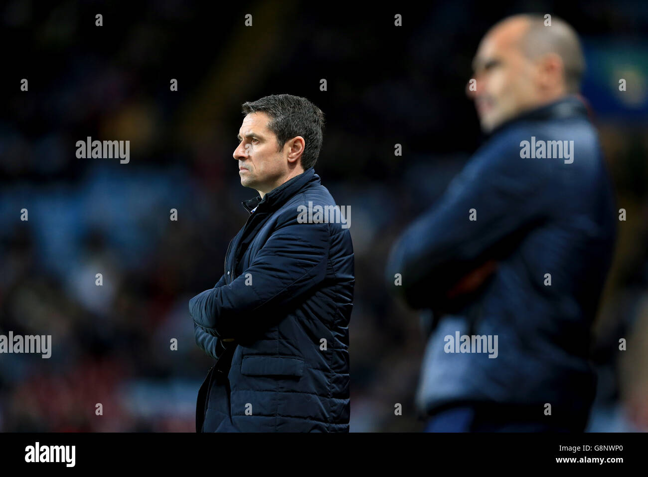 Aston Villa manager Remi Garde (left) stands on the trouchline beyond ...