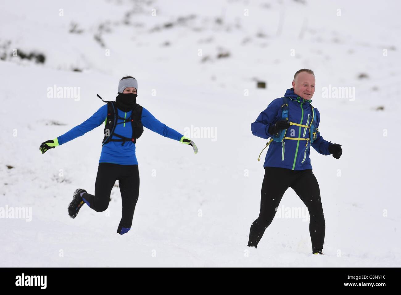 Runners make their way through the snow near Mam Tor in the Peak ...