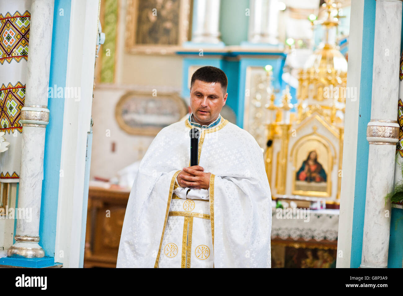 Mukyluntsi , Ukraine - 26 june, 2016: First holy communion. Priest with ...