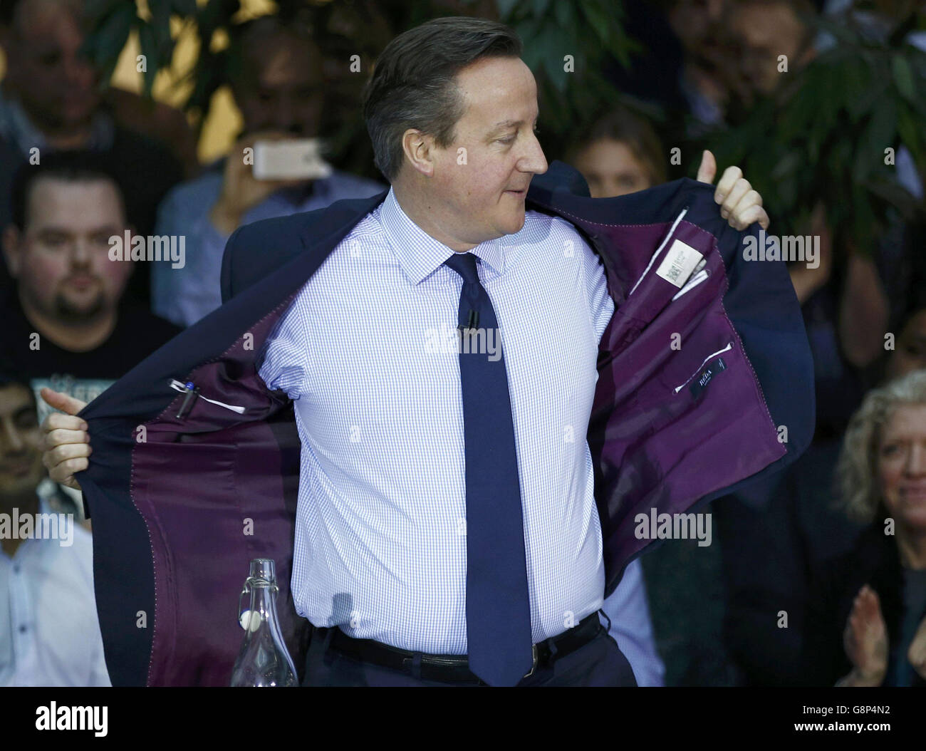 Prime Minister David Cameron removes his jacket before delivering a ...