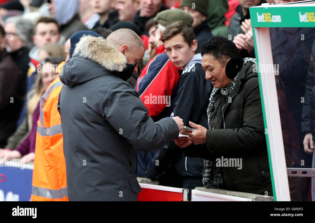 Former Stoke City player Andy Wilkinson signs autographs for a fan ...