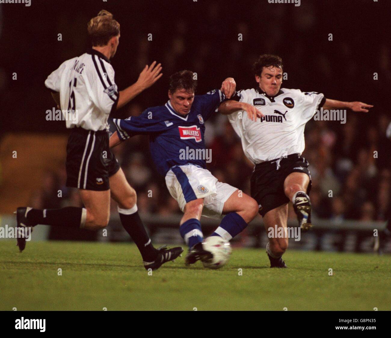 Tony Cottee of Leicester City (centre) tries a shot under pressure from ...