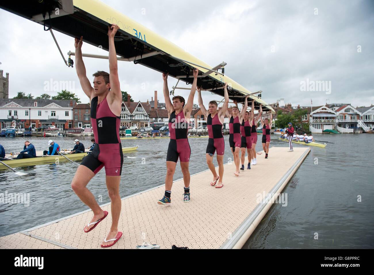 An eight crew carry their boat back to the boat shed after competing ...