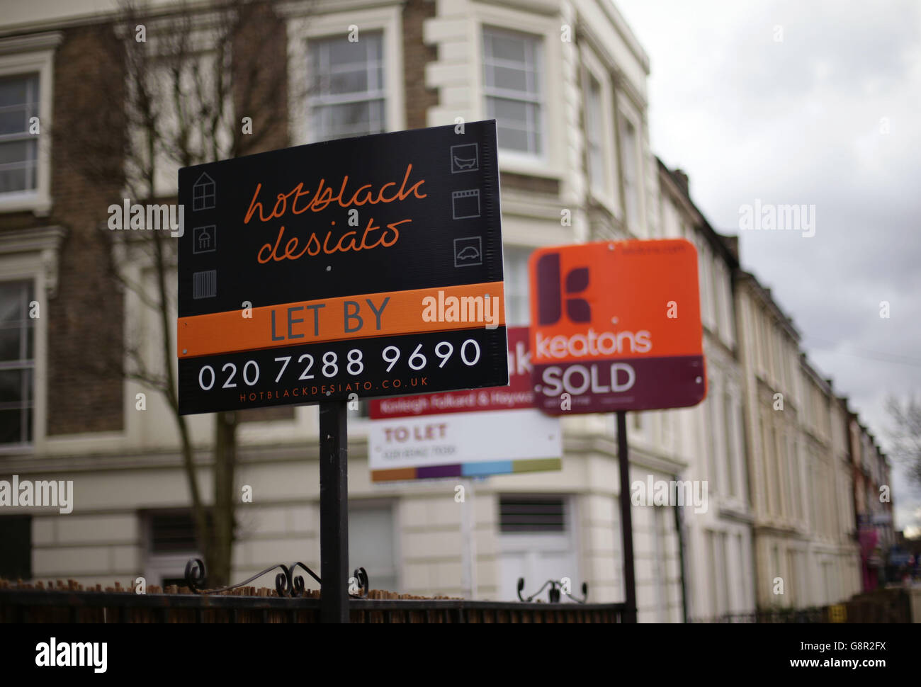A row of Sold, To Let and Let By estate agent signs outside houses in ...