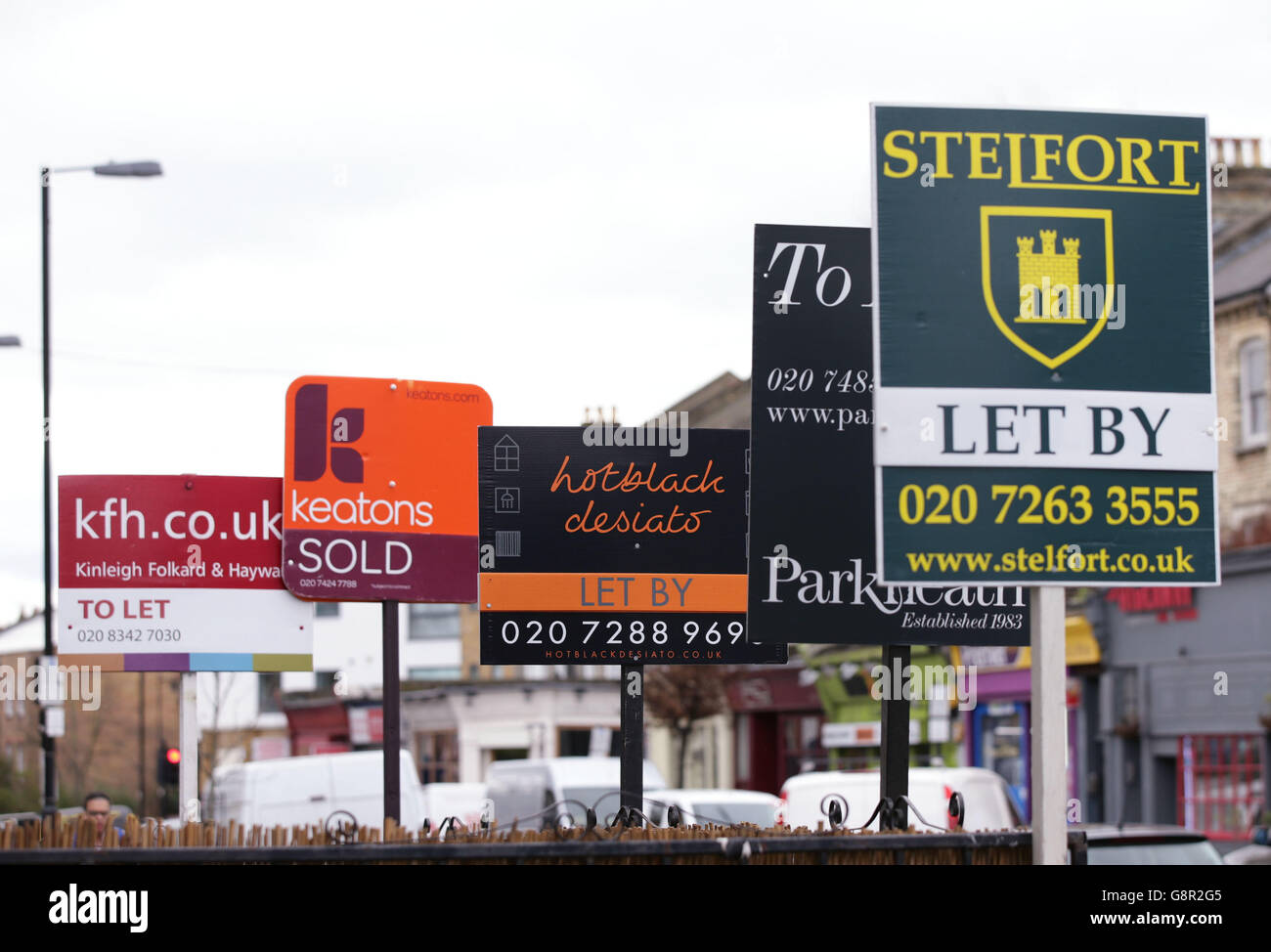 A row of Sold, To Let and Let By estate agent signs outside houses in ...