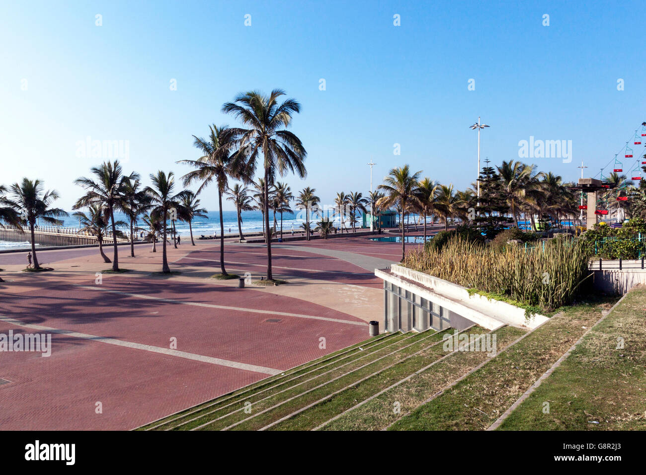 Concrete and grass stepped terrace and paved promenade on beach front ...