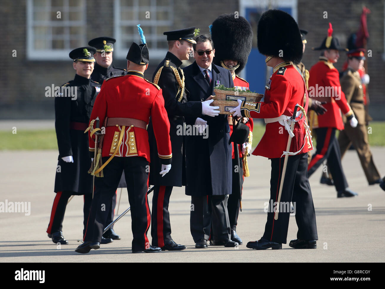 The Duke of Cambridge (centre) prepares to present sprigs of shamrock ...
