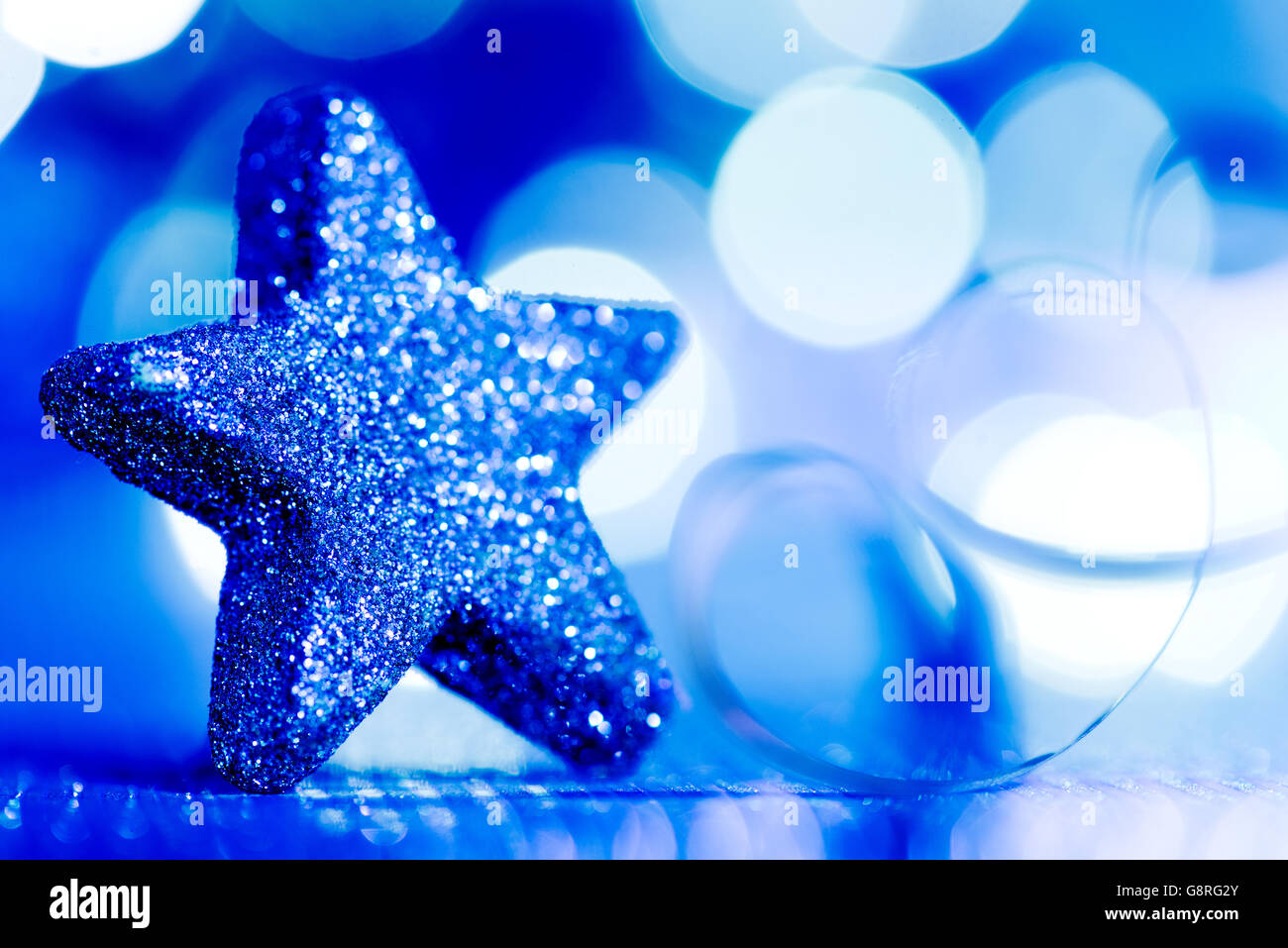 Blue Christmas star and glitter on the blue background Stock Photo - Alamy