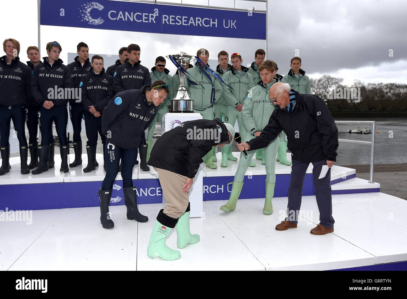 BBC Sport commentator Barry Davies (right) looks down at the coin with ...