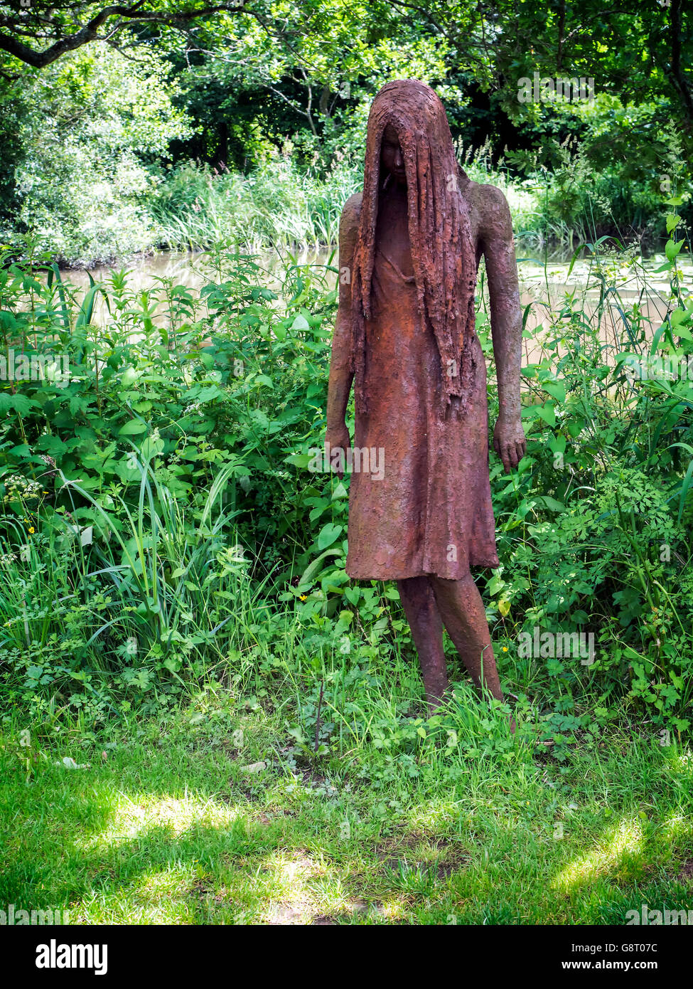 Rusting Statue of a Young Lady in the Gounds of Michelham Priory Stock ...